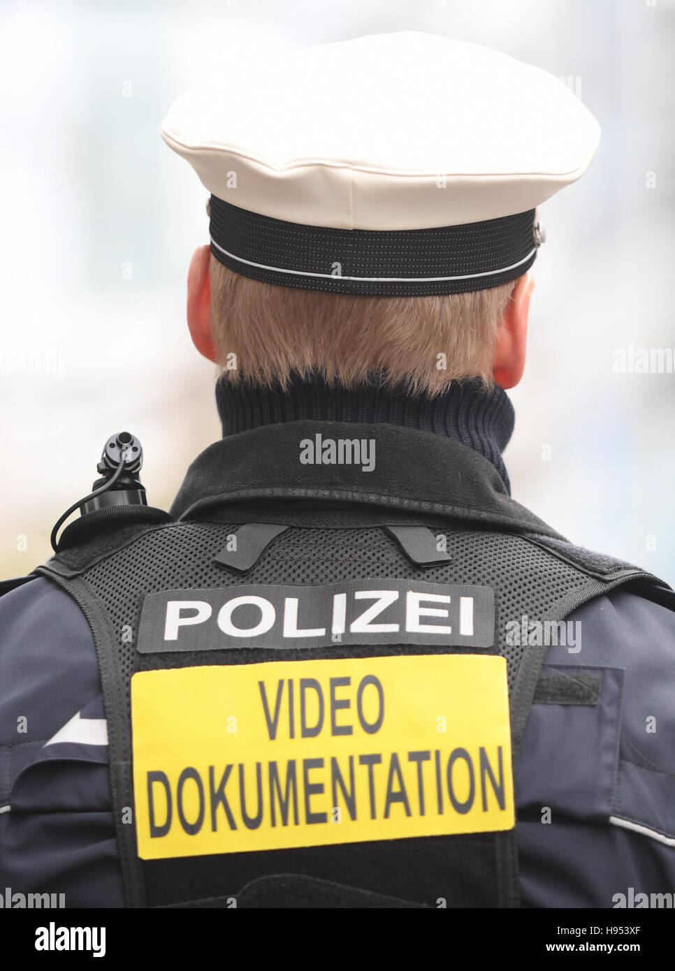 A police officer wearing a video camera on his shoulder and a sign ...