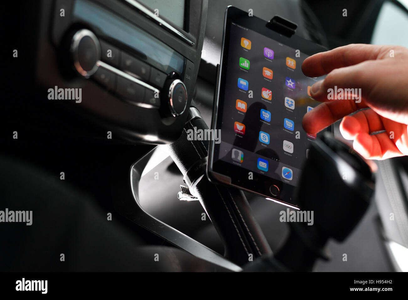 A motorist operates his iPad, which is inside a built-in holder, whilst ...