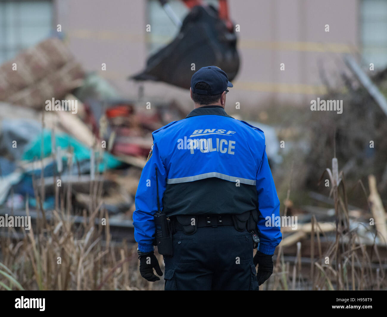BNSF railway police looks on as tracks are cleared of debris after the ...