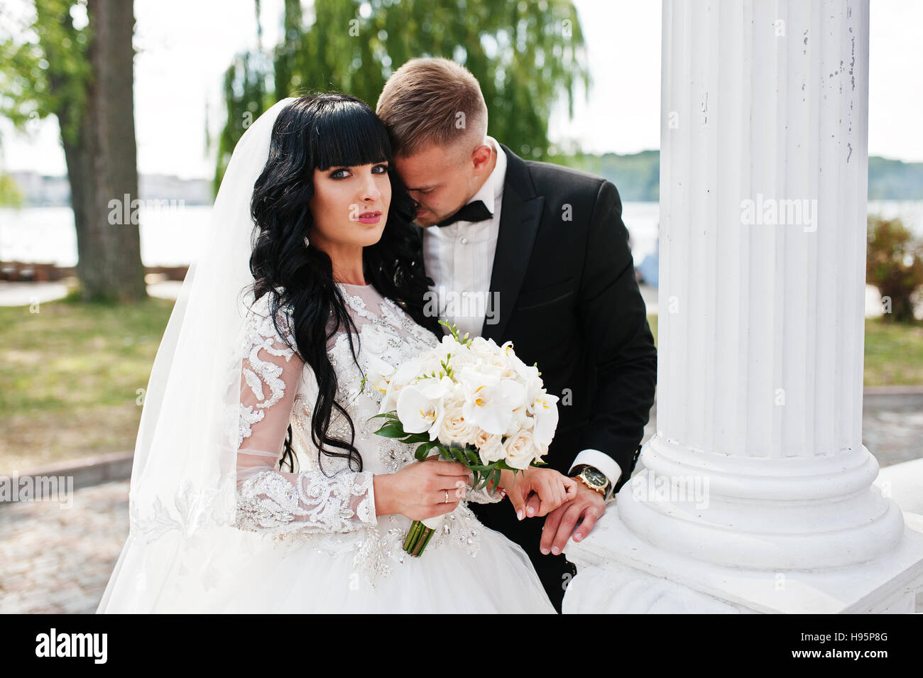 Magnificent wedding couple near white columns of arch of love Stock ...