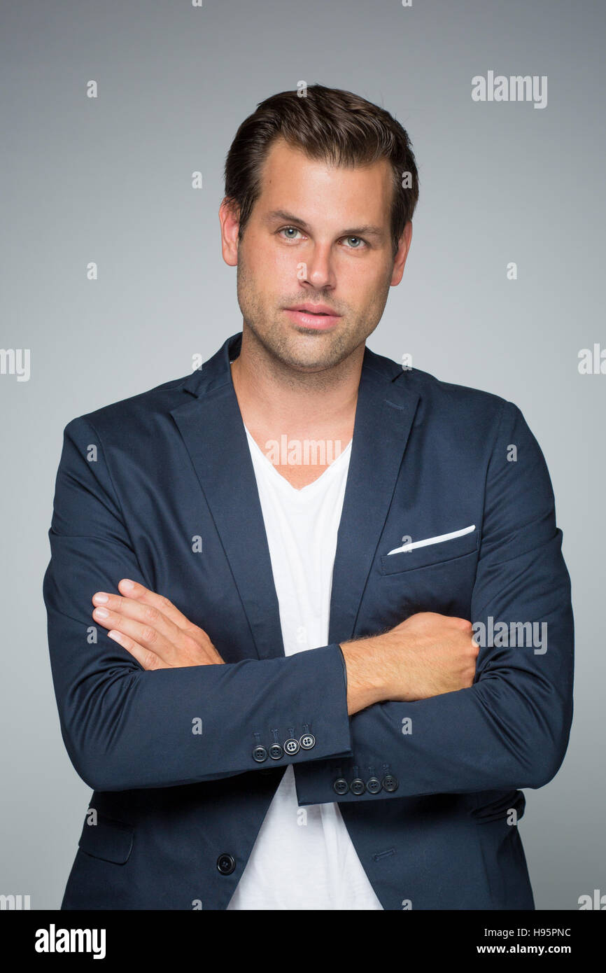Portrait of a smart young man standing with arms crossed Stock Photo ...