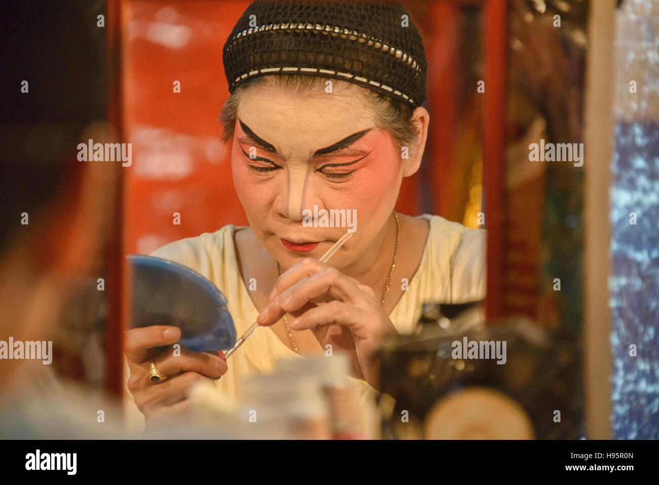 Chinese opera performer putting on a makeup at the Vegetarian Festival ...