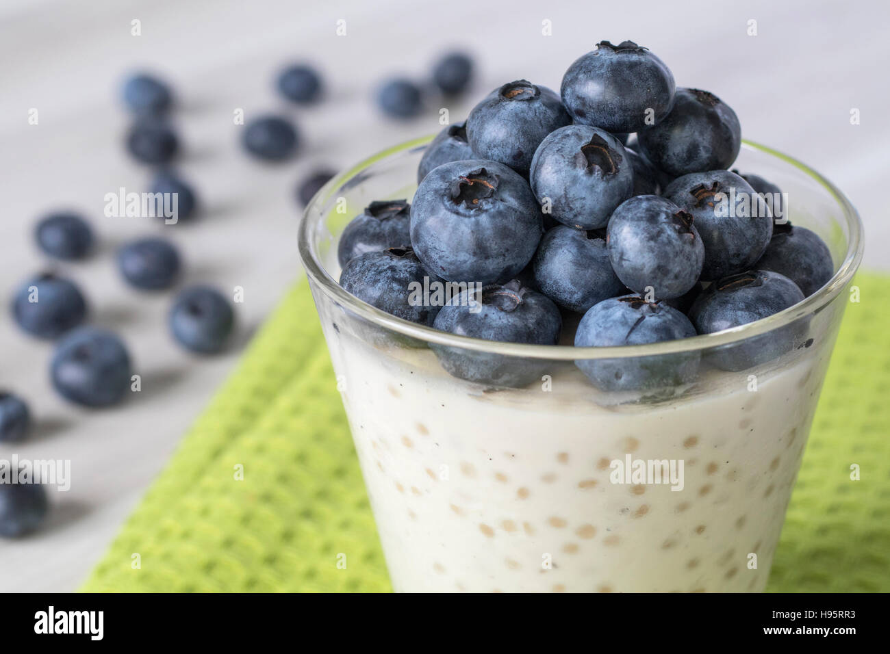 Tapioca pudding in a clear glass with fresh blueberries on the top ...