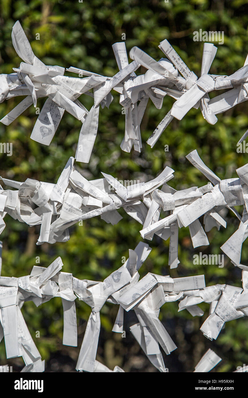 Random fortunes written on paper strips and tied to rope fence for good ...