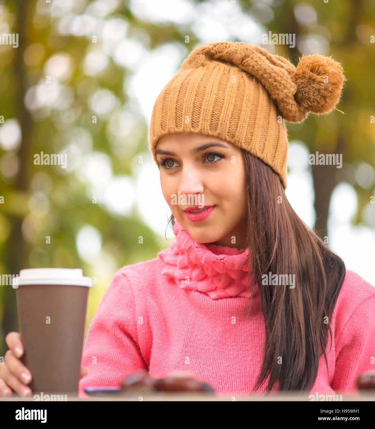 woman drinking coffee on park bench under fall foliage Stock Photo - Alamy