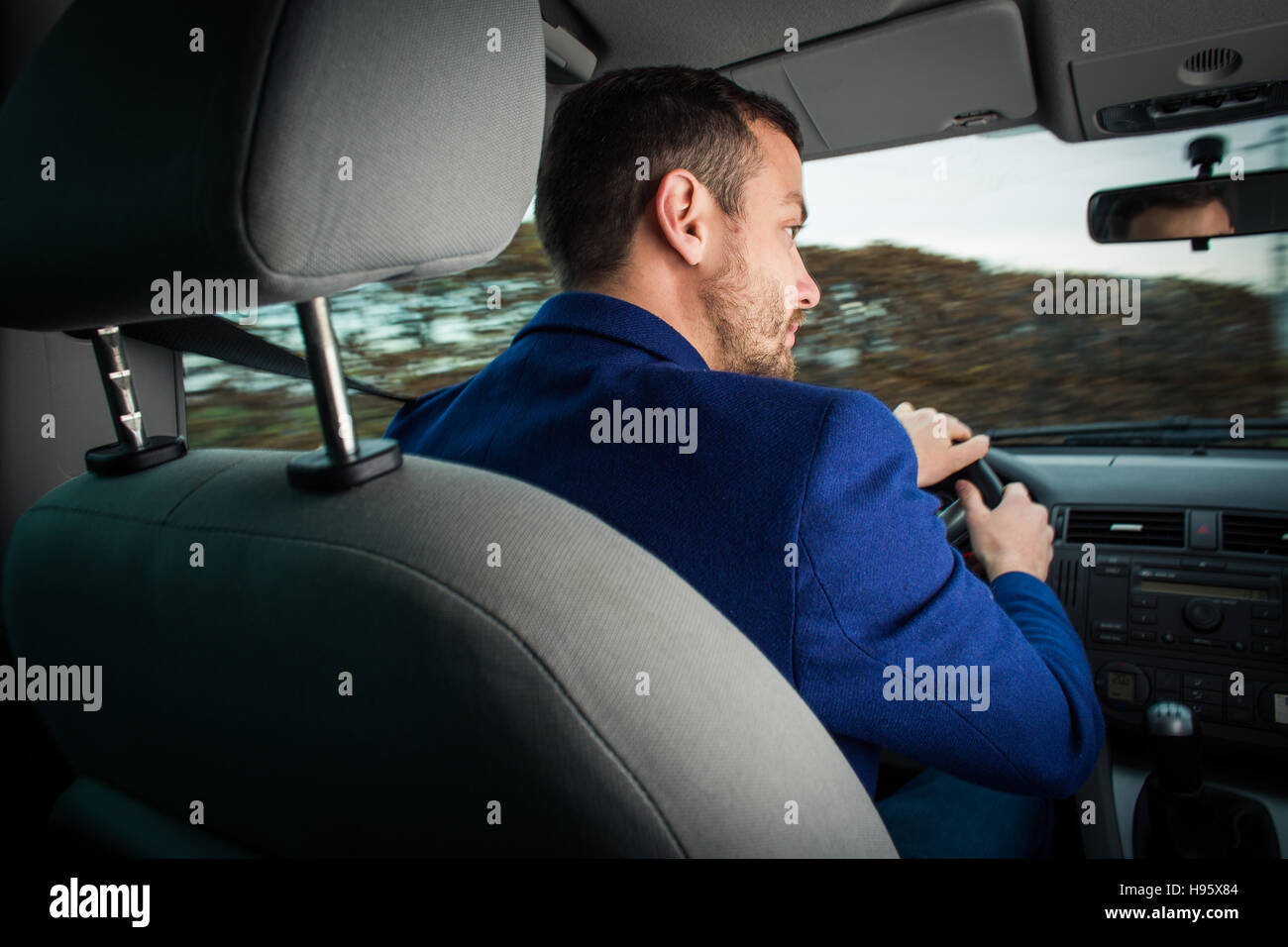 Driving a car - handsome young man driving fast his car (shallow DOF ...