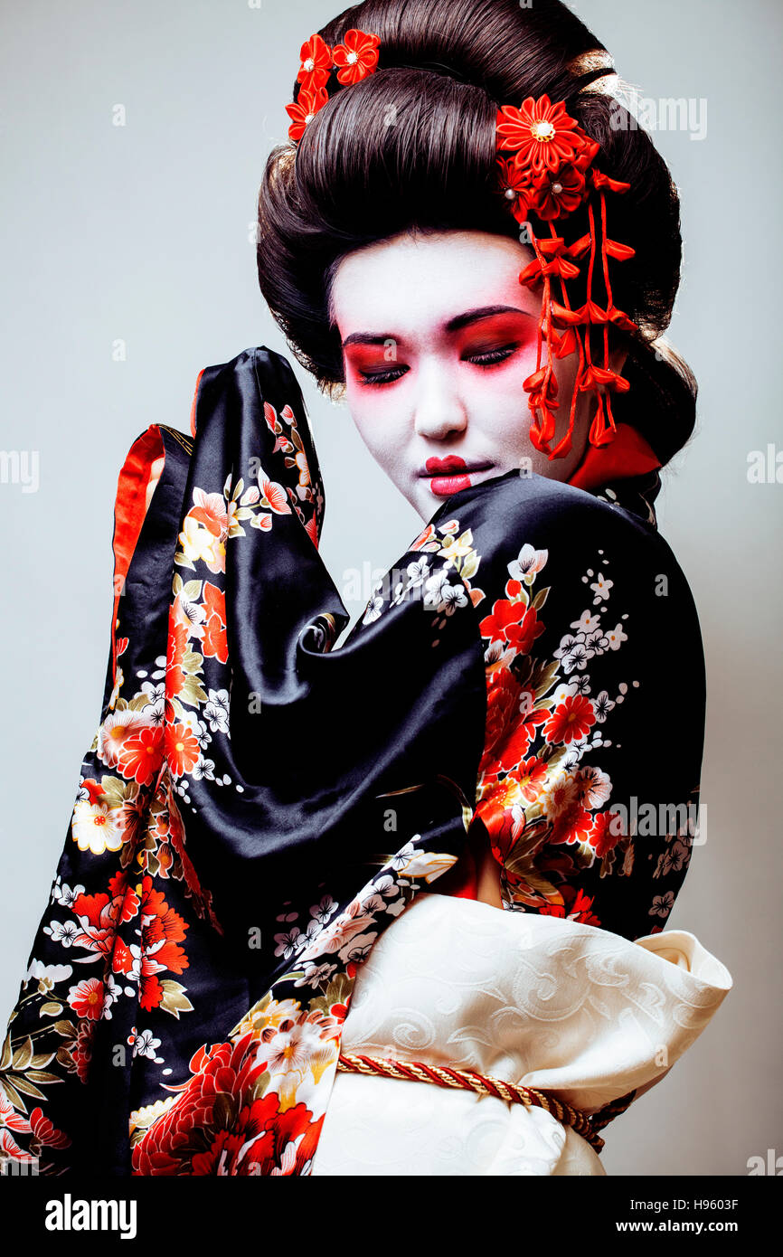 young pretty geisha in black kimono among sakura, asian ethno Stock ...