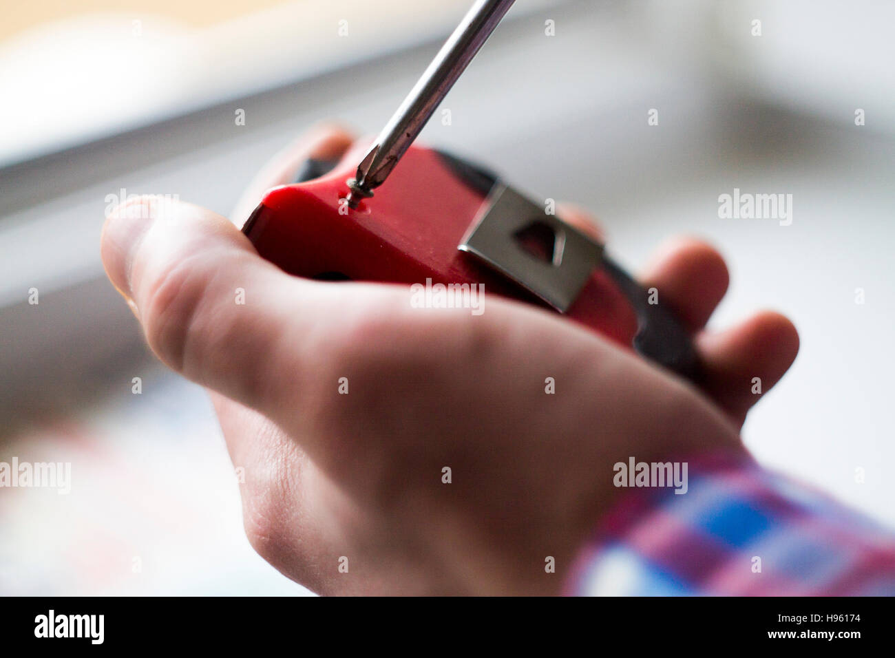 man unscrews the screw with a screwdriver Stock Photo - Alamy
