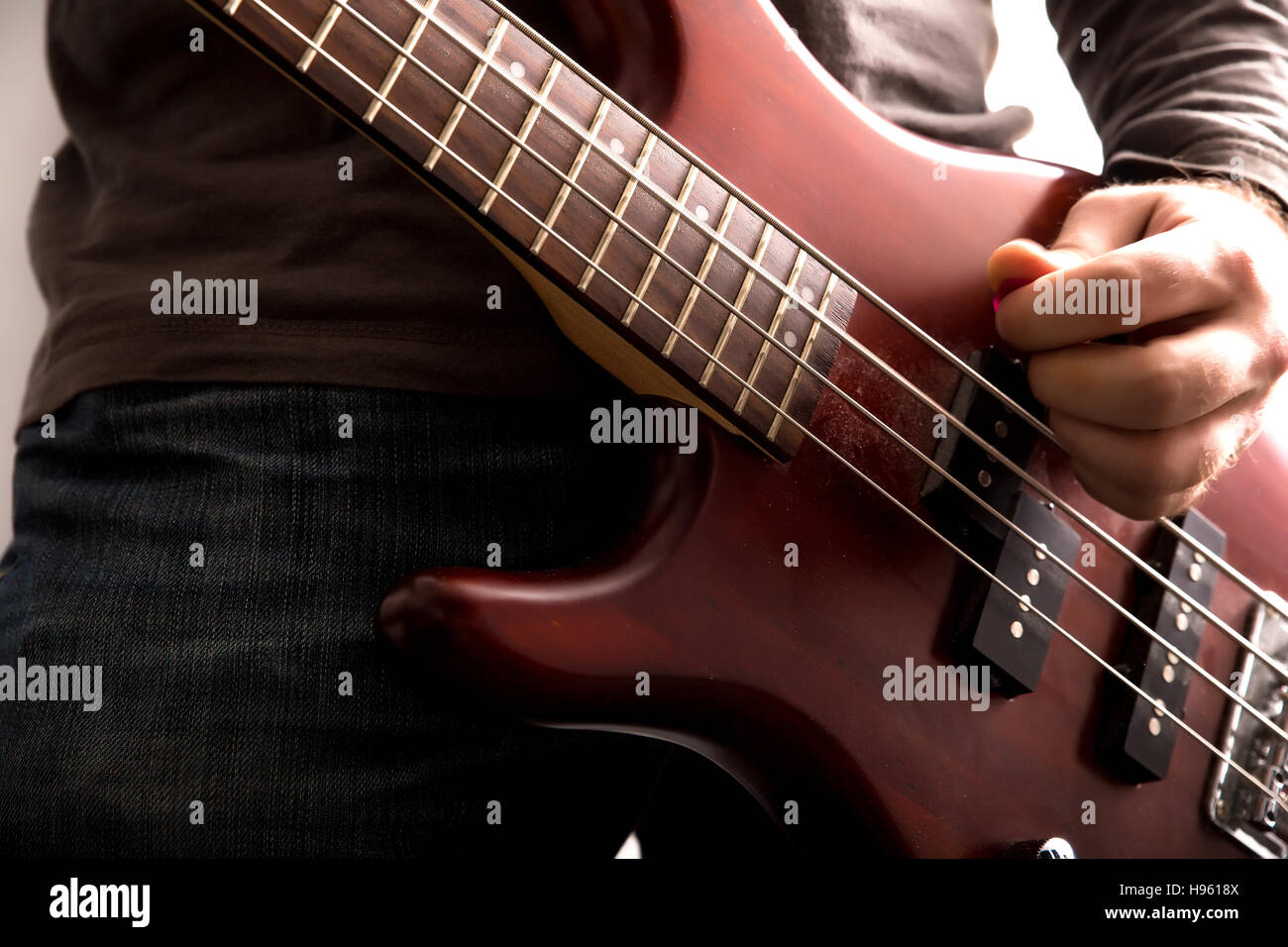A rock musician playing the bass in a rehearsal room Stock Photo - Alamy