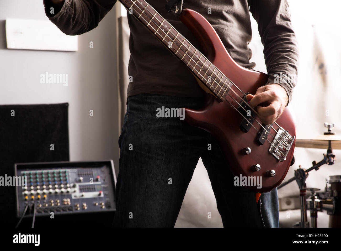 A rock musician playing the bass in a rehearsal room Stock Photo - Alamy
