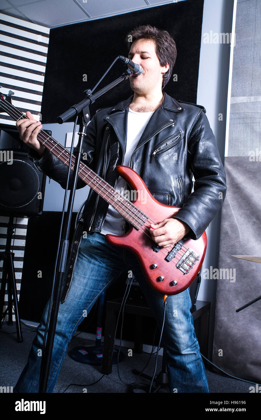A Rock musician playing passionately bass in the rehearsal Studio Stock ...