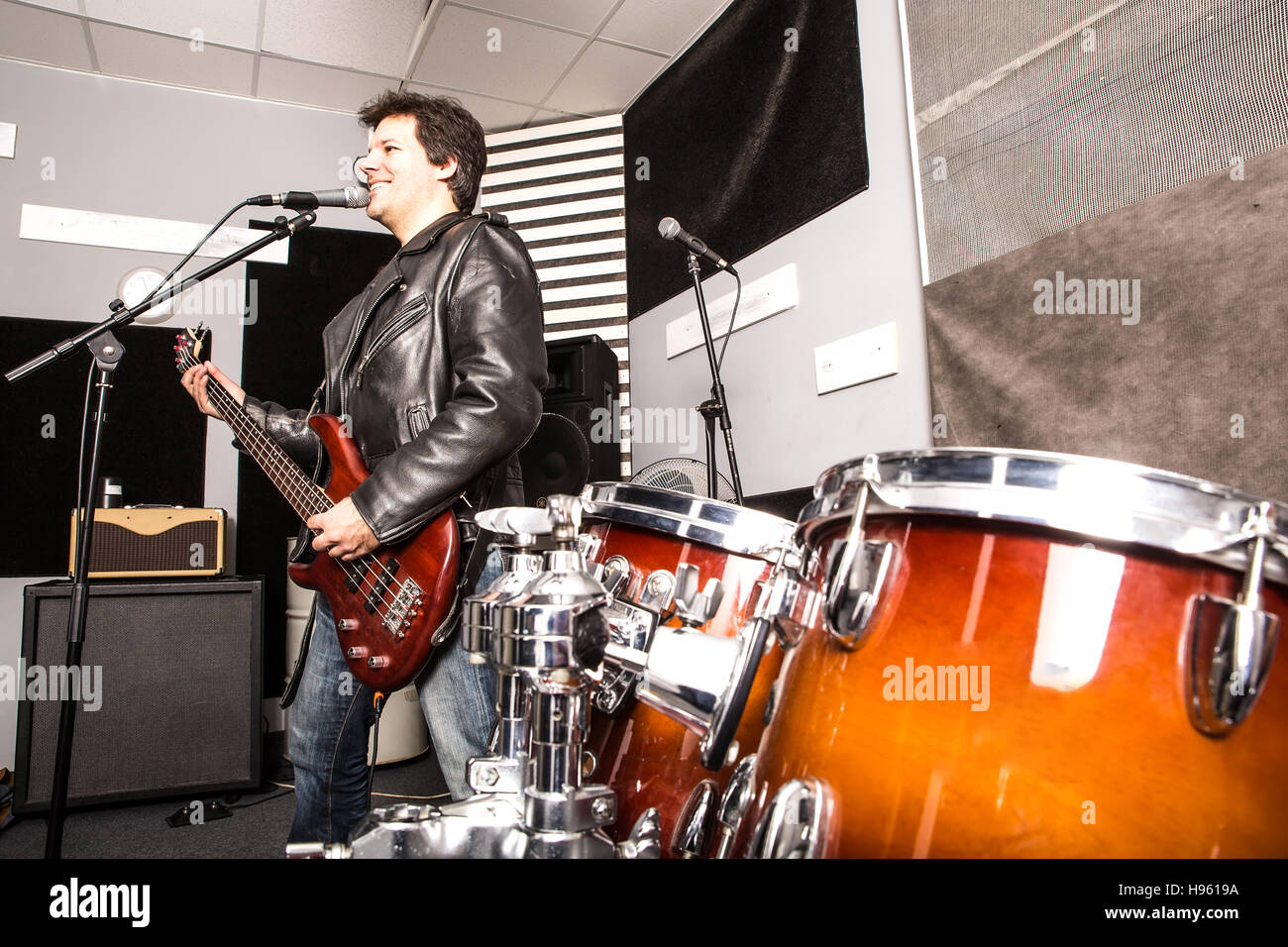 A Rock musician playing passionately bass in the rehearsal Studio Stock ...