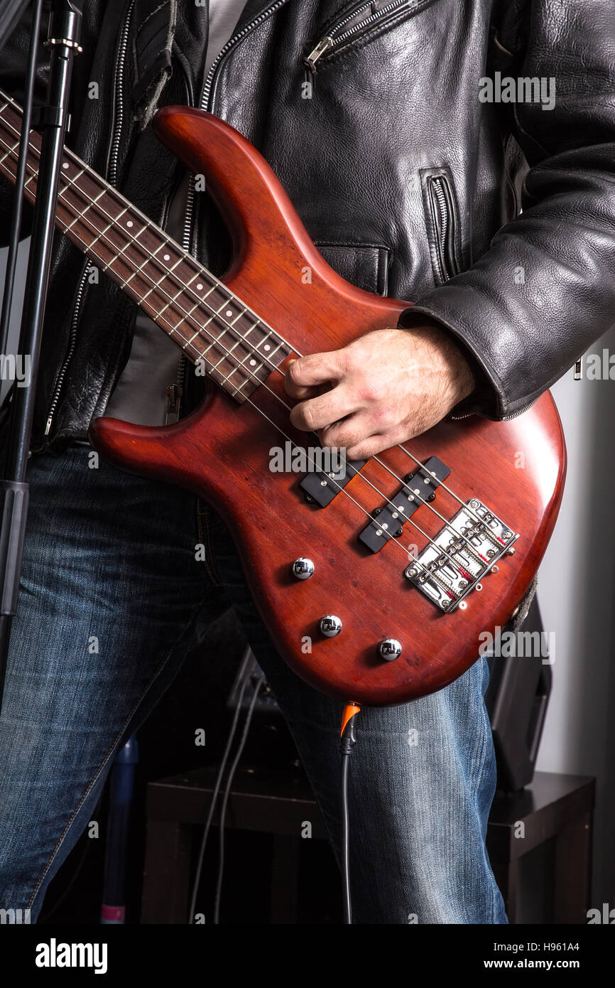 A Rock musician playing passionately bass in the rehearsal Studio Stock ...