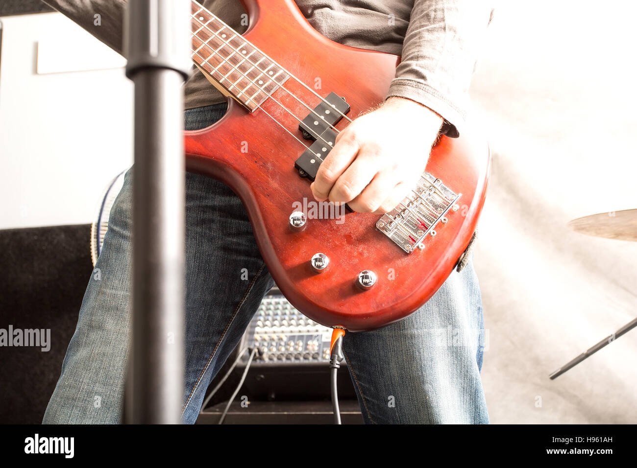 A Rock musician playing passionately bass in the rehearsal Studio Stock ...