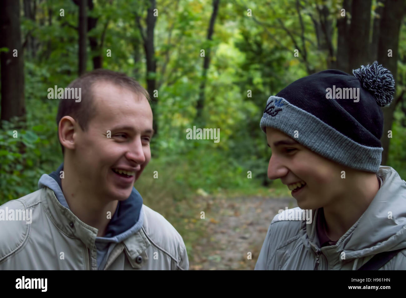 two young men laughing in the forest Stock Photo - Alamy