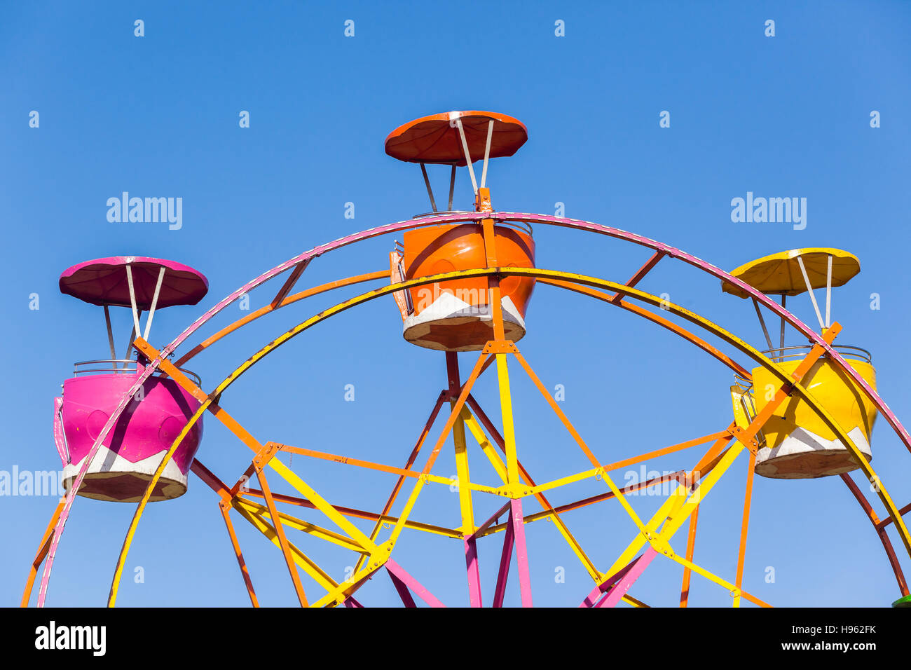 Amusement playground ferris wheel with three cabin pods in blue sky ...