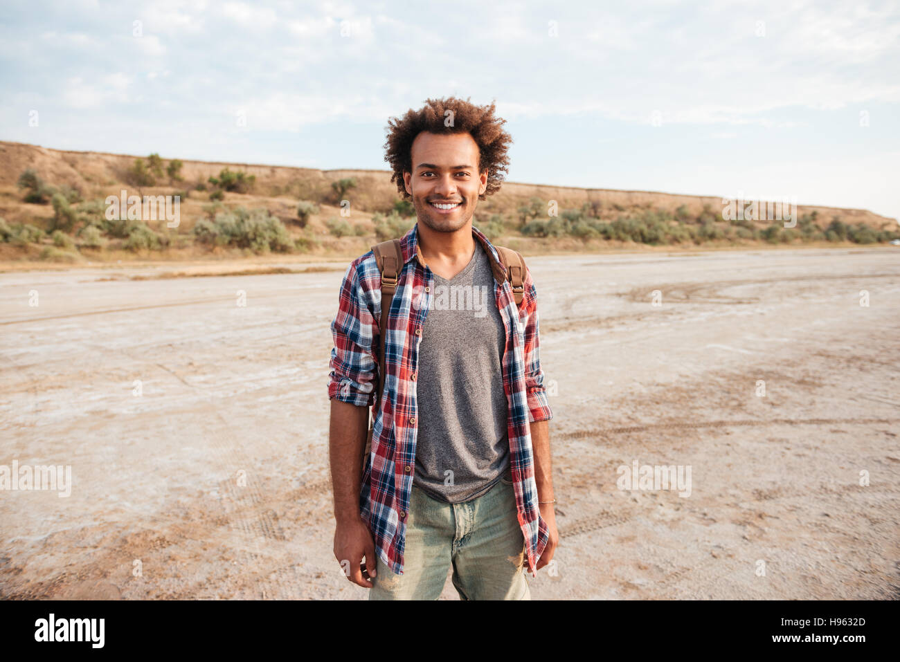 Happy african american young man with backpack standing outdoors Stock ...