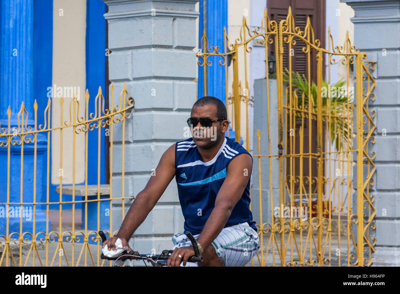 Top half of a portrait of an ordinary black Cuban man riding a bicycle ...