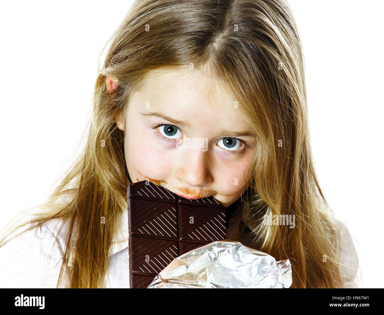 Cute little girl eating tablet of chocolate, isolated on white ...