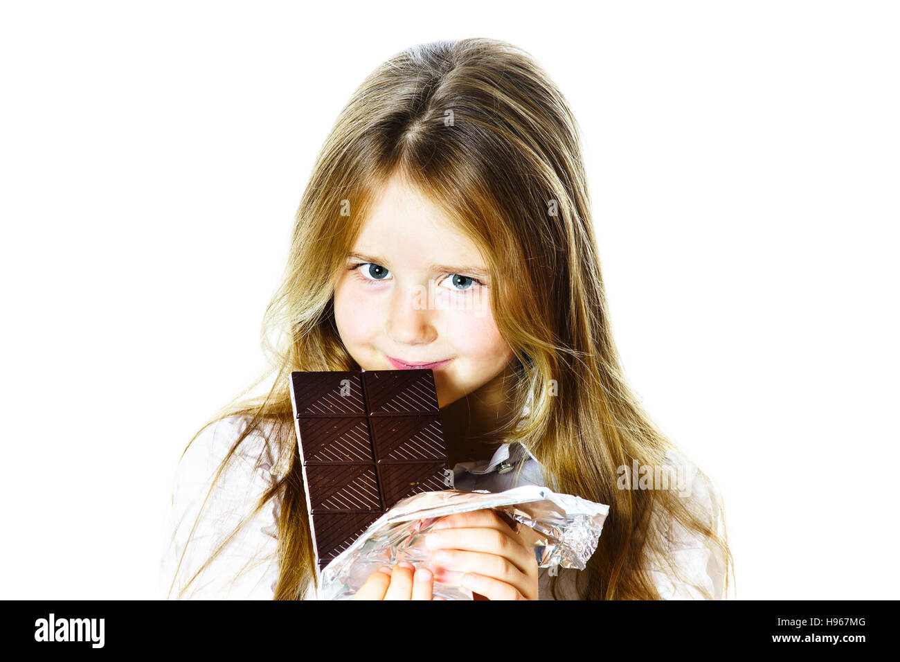 Cute little girl eating tablet of chocolate, isolated on white ...