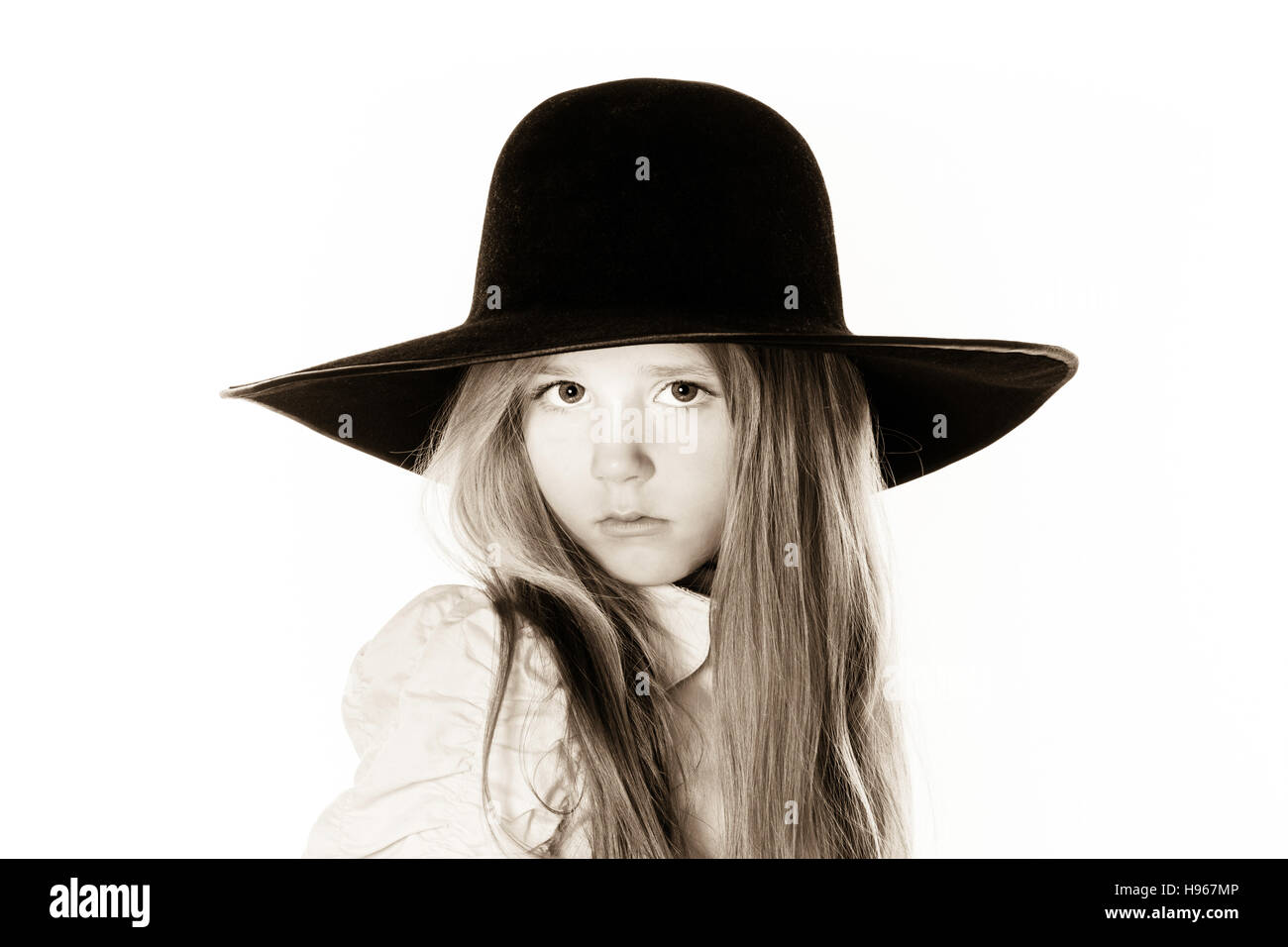 LIttle girl posing like a model in mother's hat, isolated on white ...
