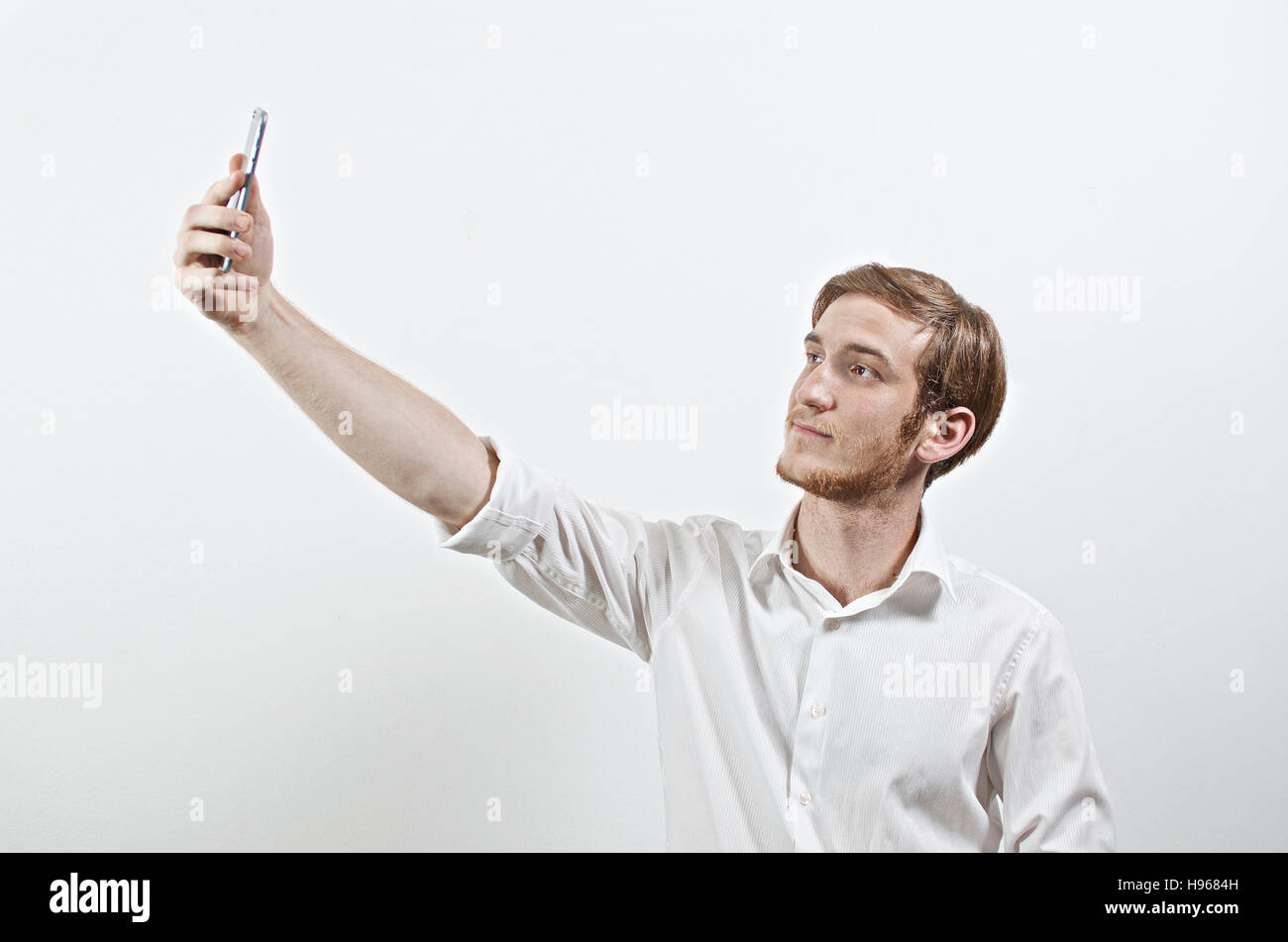 Young Smiling Adult Man in White Shirt Takes a Selfie with His Smart ...