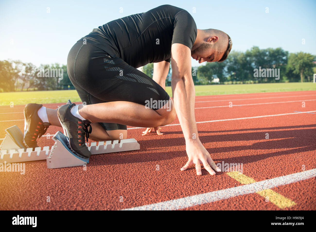 Male athlete on starting position at athletics running track Stock ...