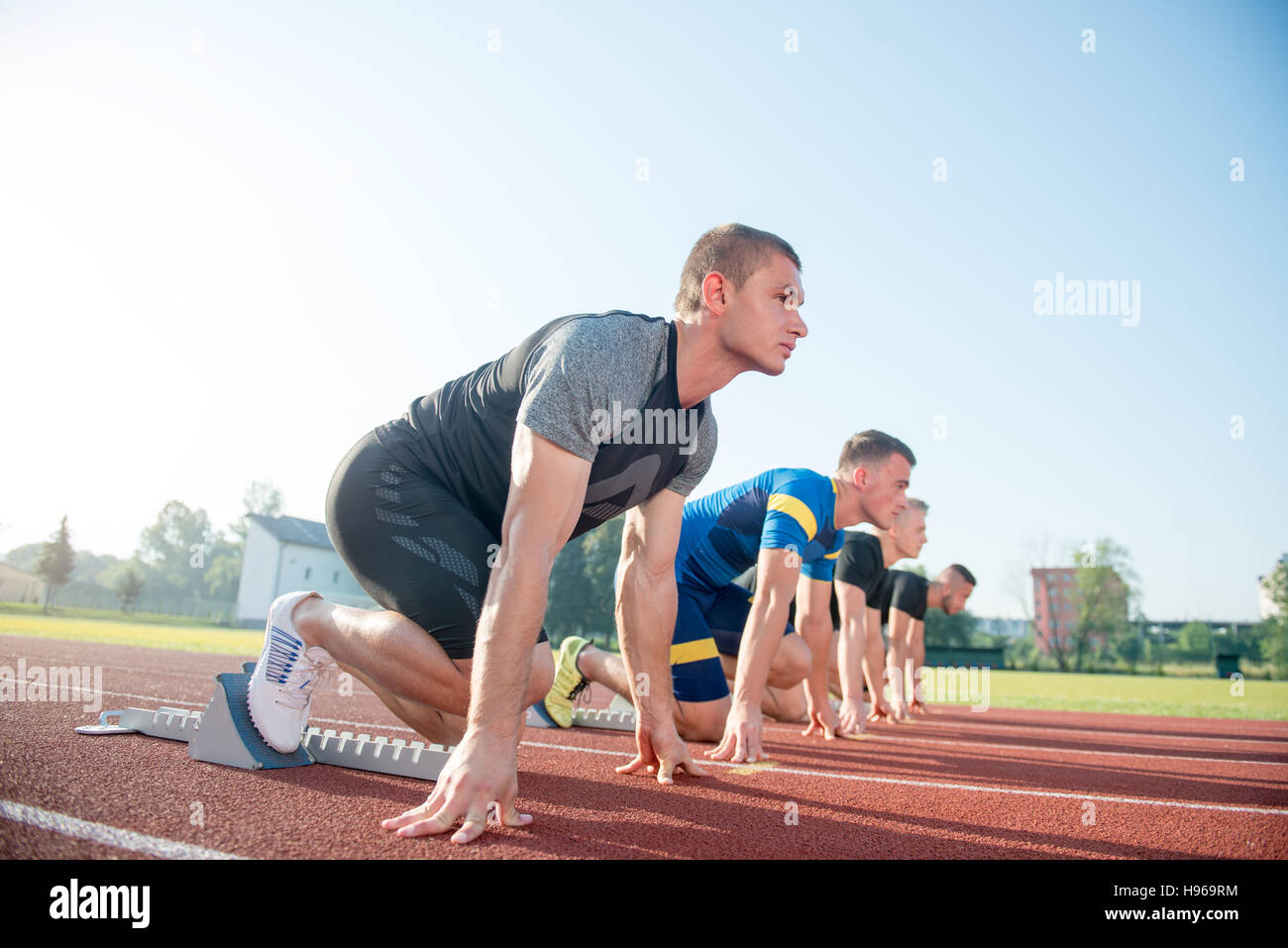 Close-up side view of cropped people ready to race on track field Stock ...