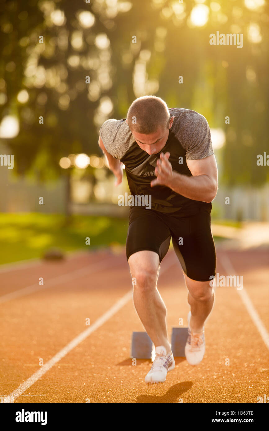 Sprinter leaving starting blocks on the running track. Explosive start ...