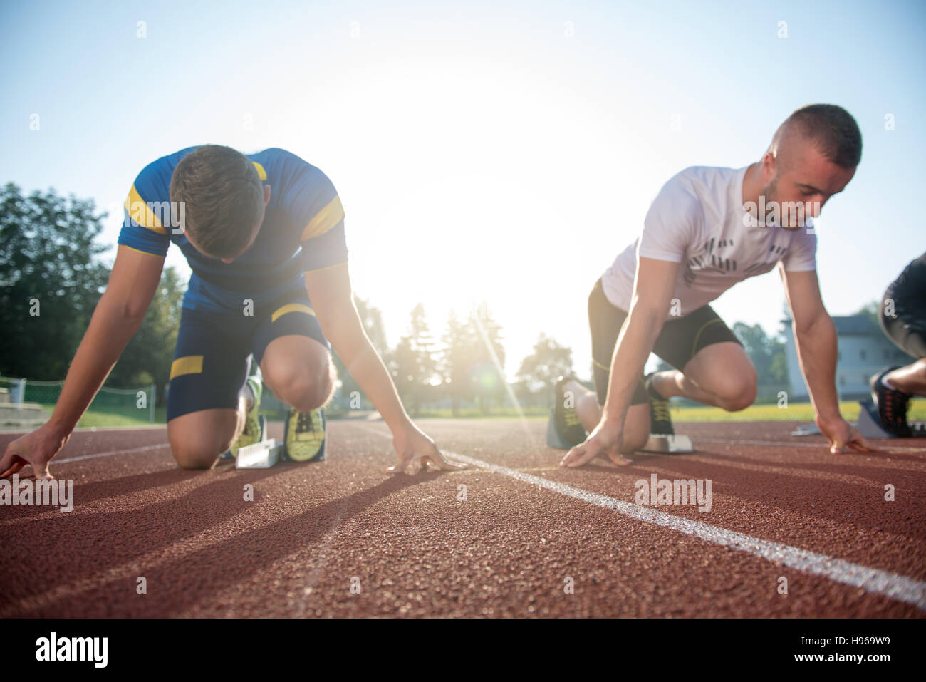Close-up side view of cropped people ready to race on track field Stock ...