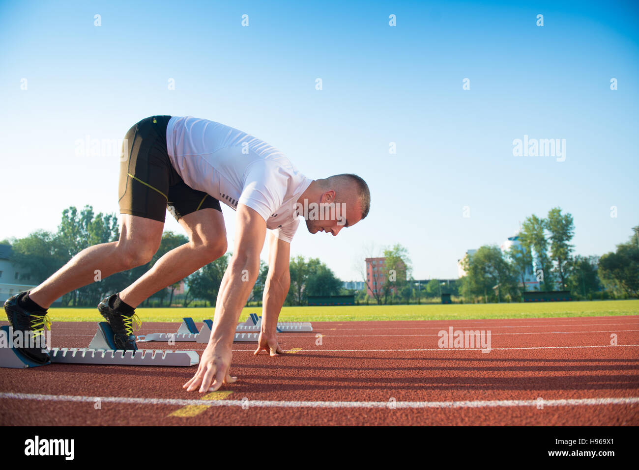 Male athlete on starting position at athletics running track Stock ...