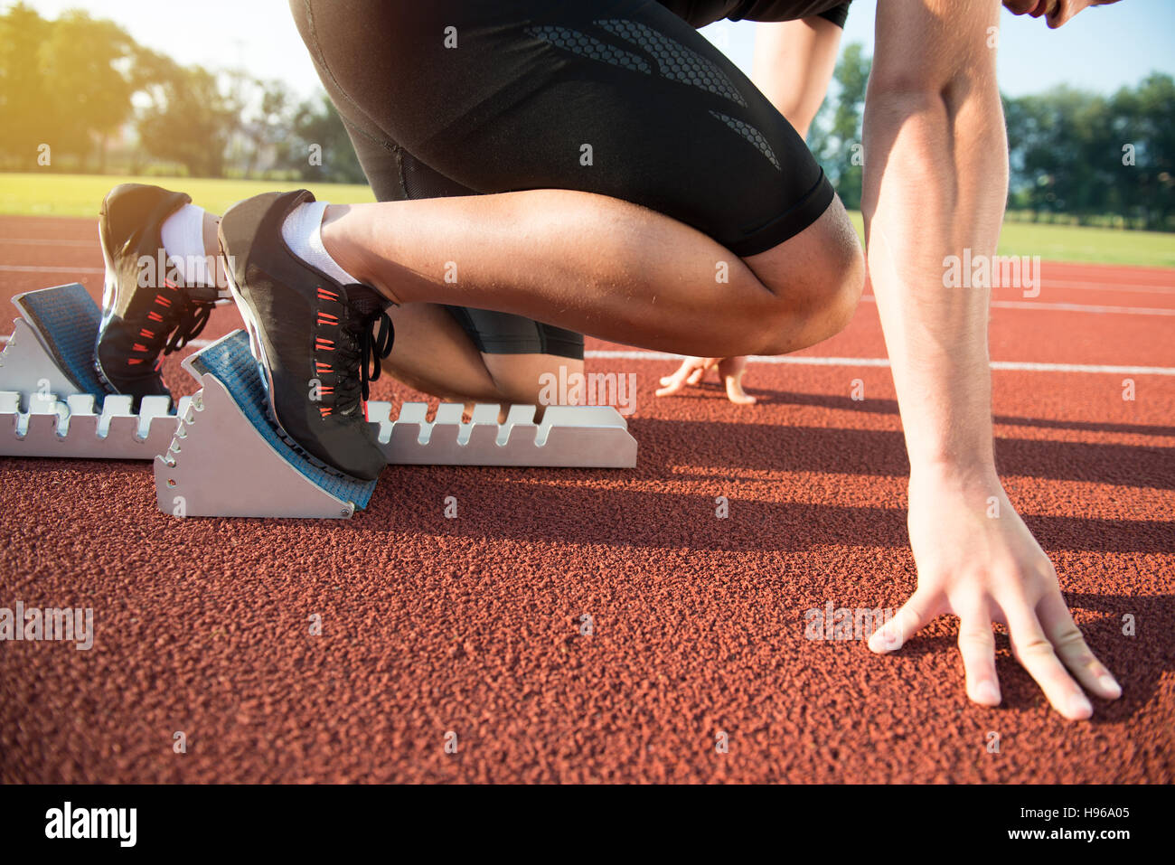 Male athlete on starting position at athletics running track Stock ...
