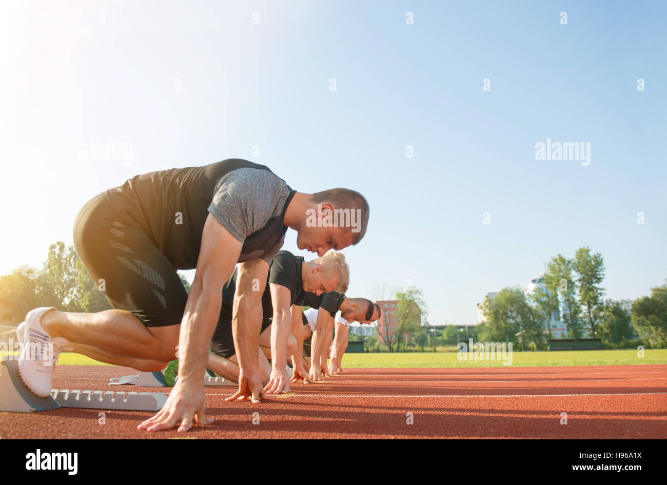Close-up side view of cropped people ready to race on track field Stock ...