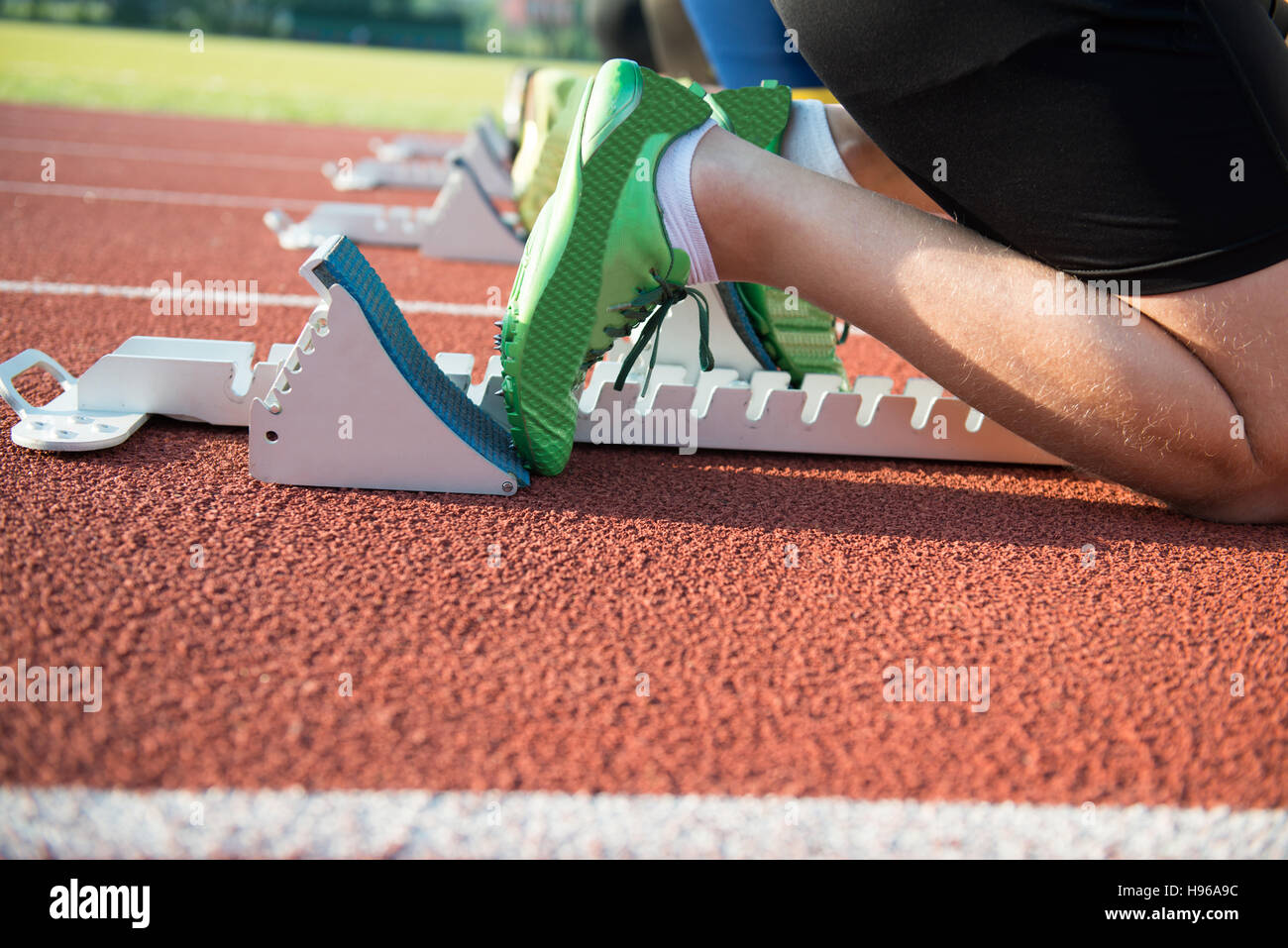 Feet on starting block ready for a spring start Stock Photo - Alamy