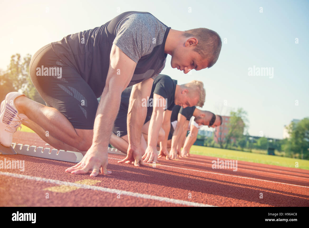 Close-up side view of cropped people ready to race on track field Stock ...