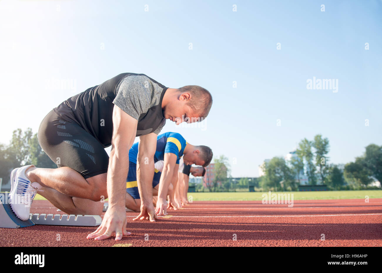 Close-up side view of cropped people ready to race on track field Stock ...