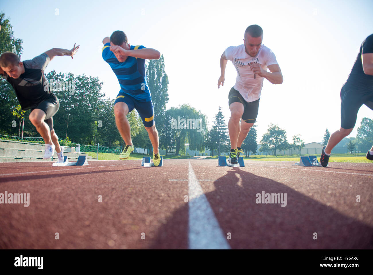 Close-up side view of cropped people ready to race on track field Stock ...