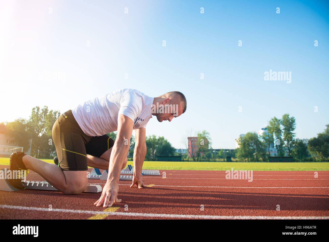 Male athlete on starting position at athletics running track Stock ...