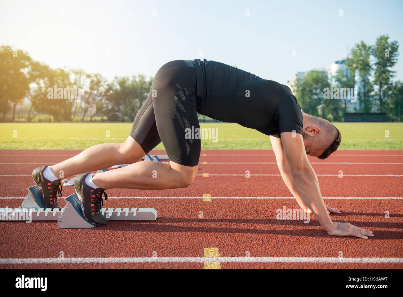 Male athlete on starting position at athletics running track Stock ...