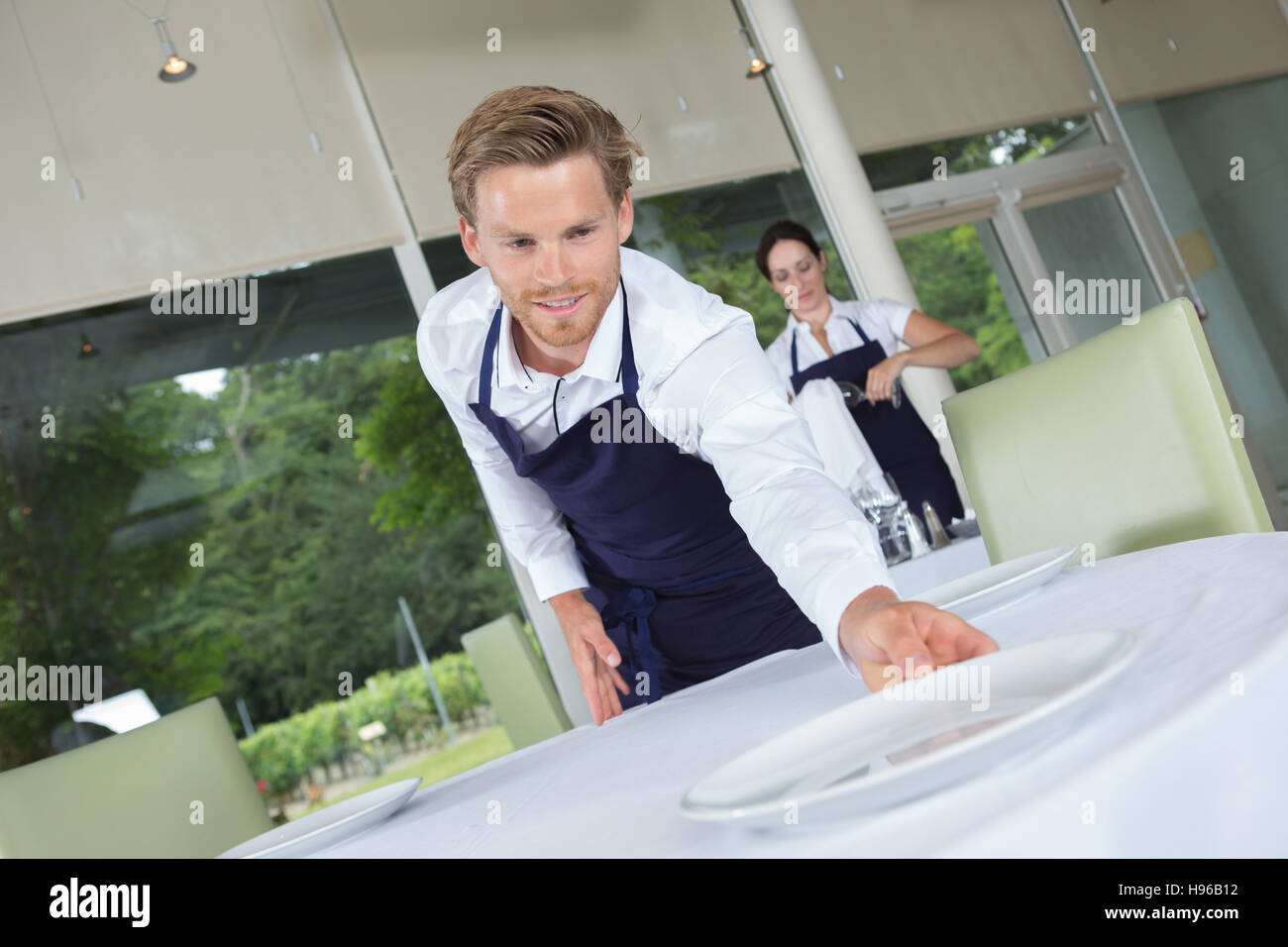 handsome happy waiter setting up a table at restaurant Stock Photo - Alamy