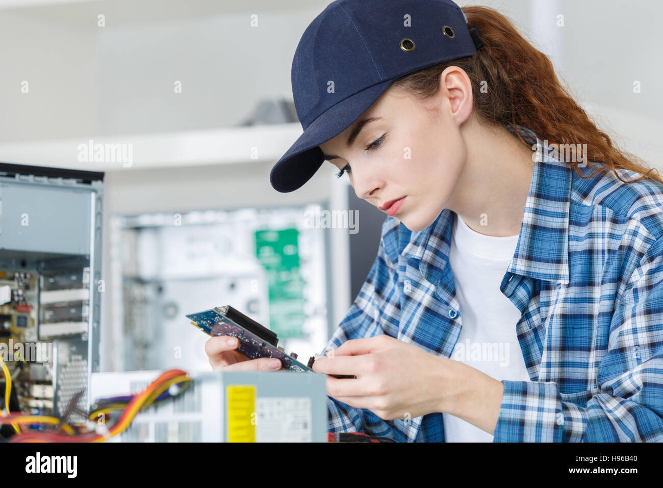 Young female computer repair person Stock Photo - Alamy