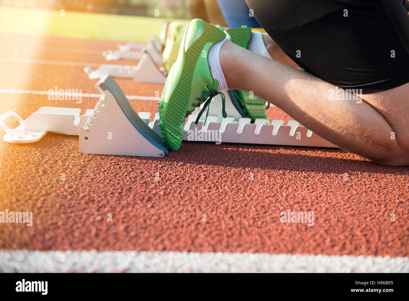 Feet on starting block ready for a spring start Stock Photo - Alamy