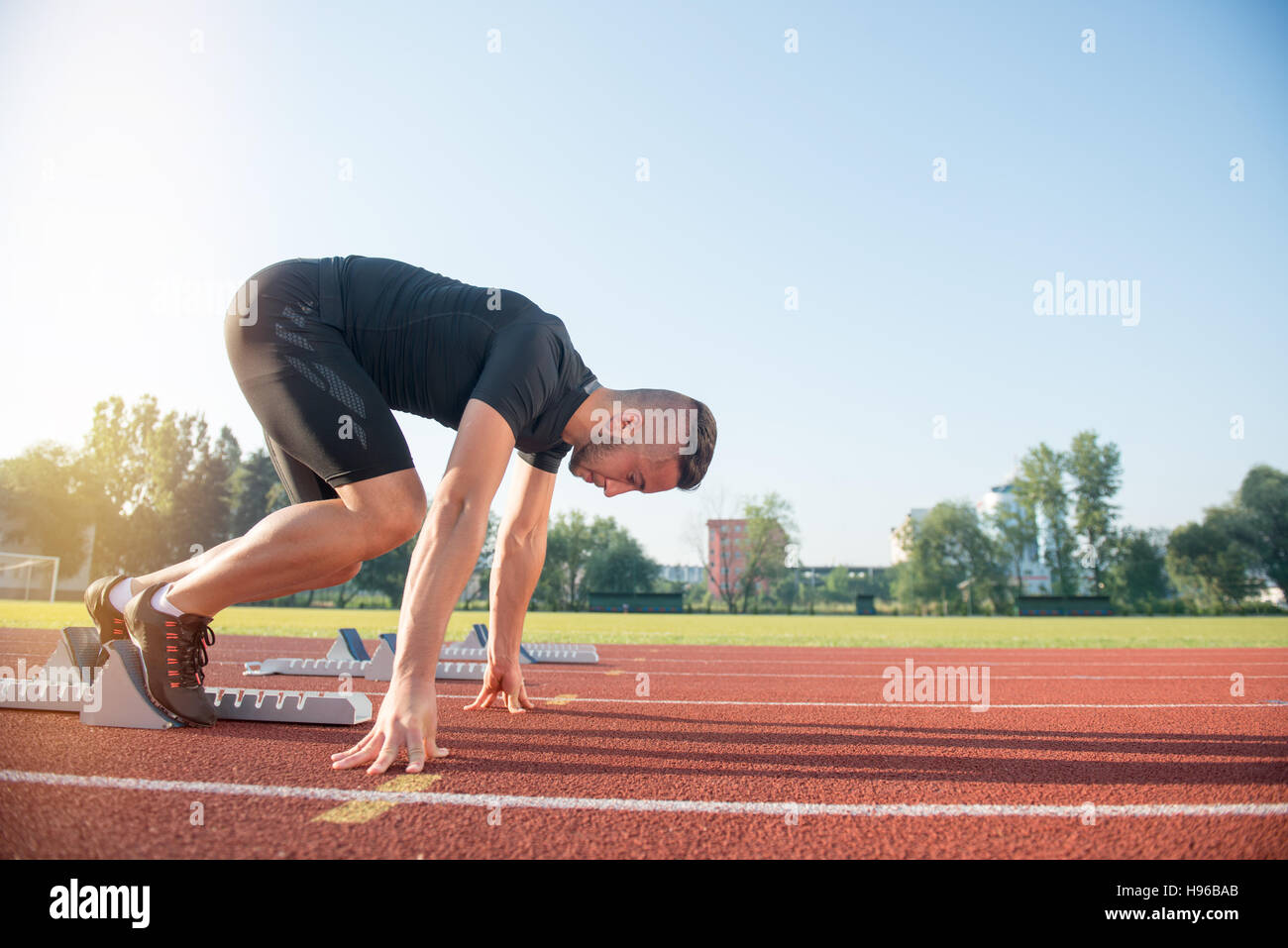 Male athlete on starting position at athletics running track Stock ...