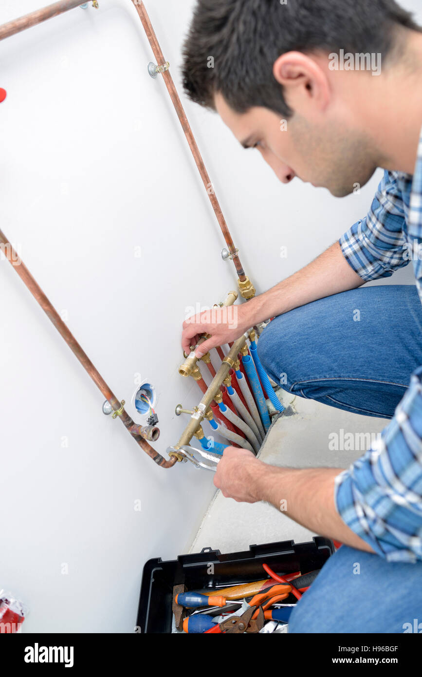 Plumber fixing a water system Stock Photo - Alamy