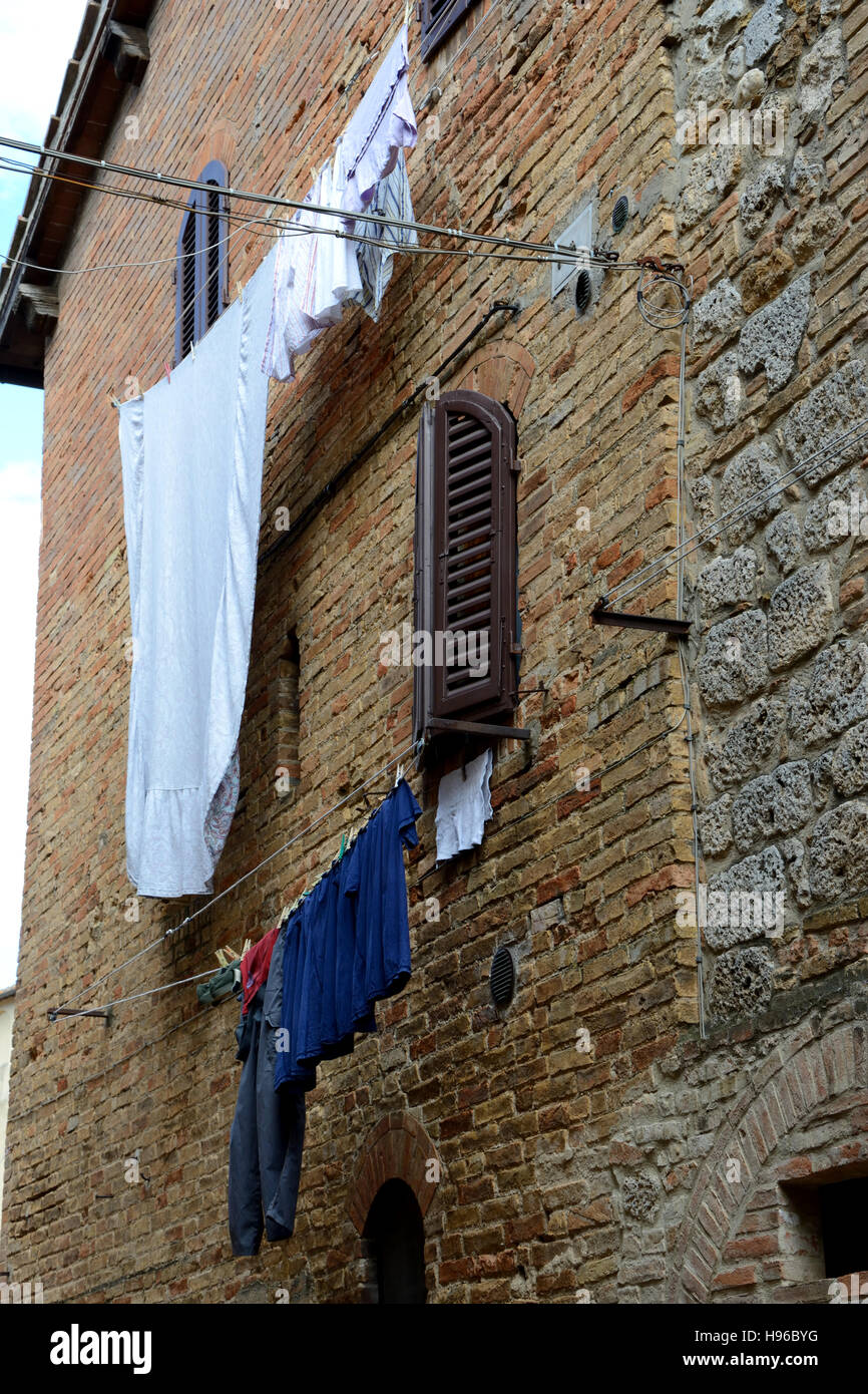 Clothes hanging at old brick and stone wall Stock Photo - Alamy