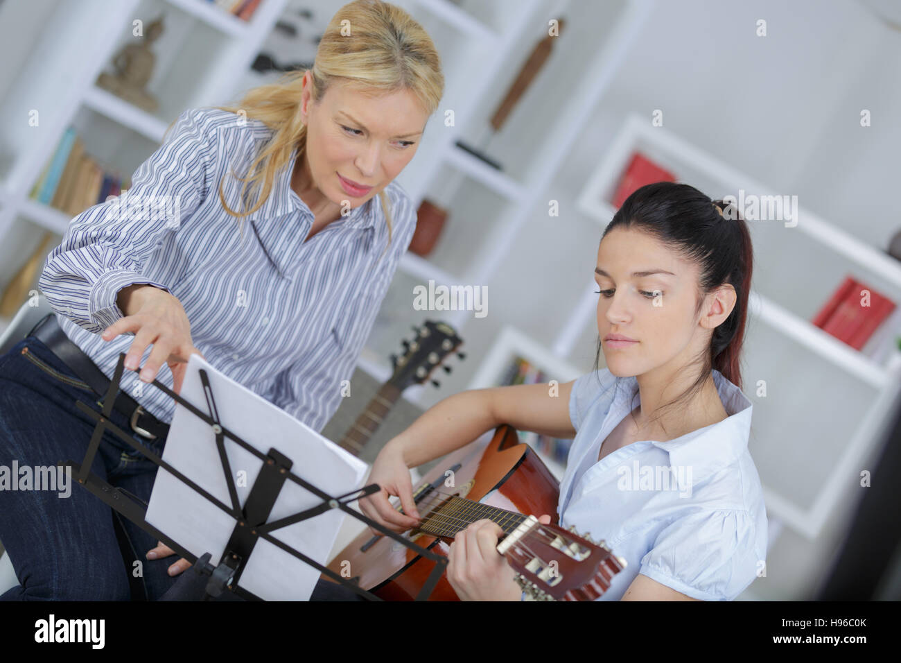 teenage girl learning to play the guitar Stock Photo - Alamy