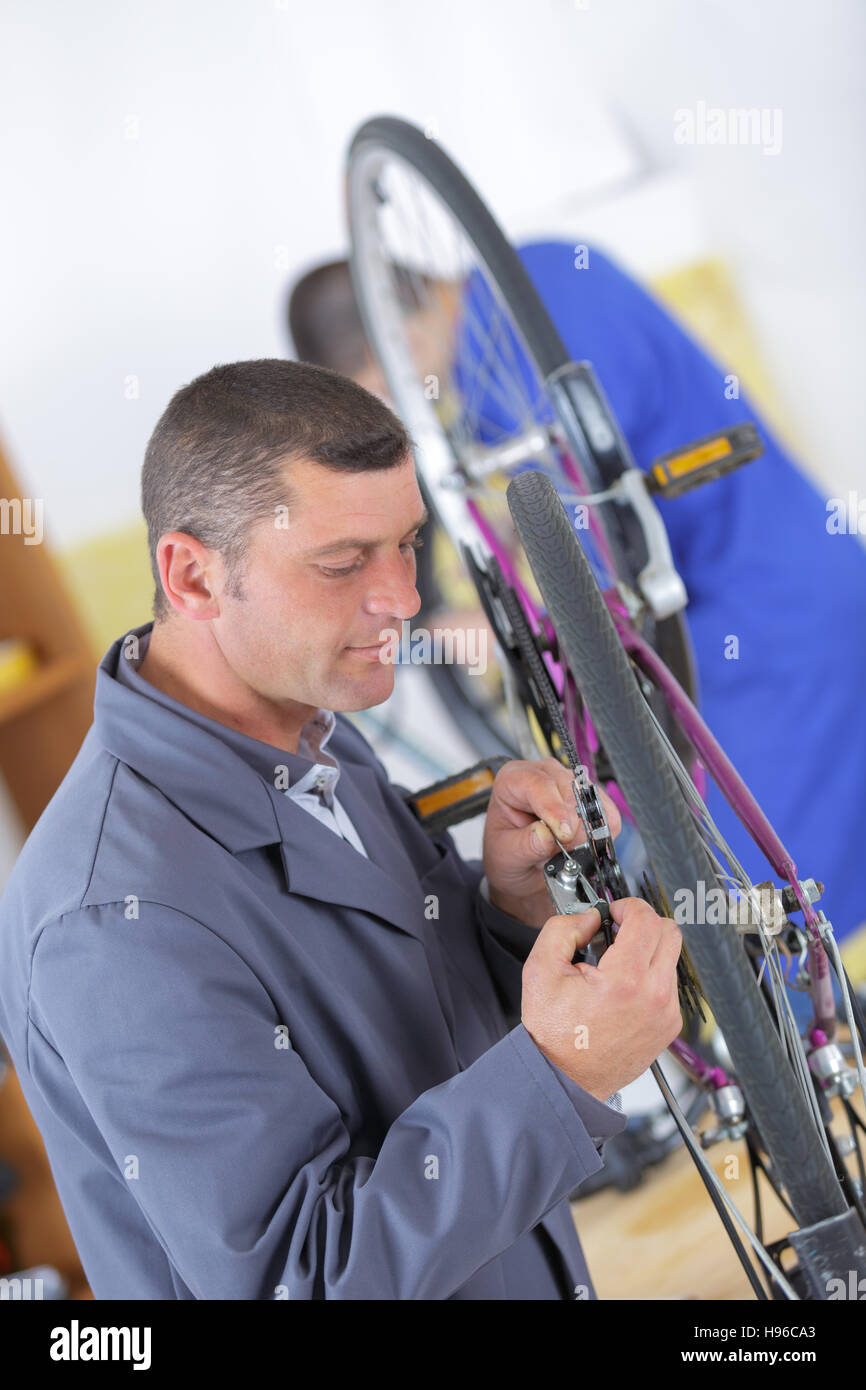 stylish bicycle mechanic doing his professional work in workshop Stock ...