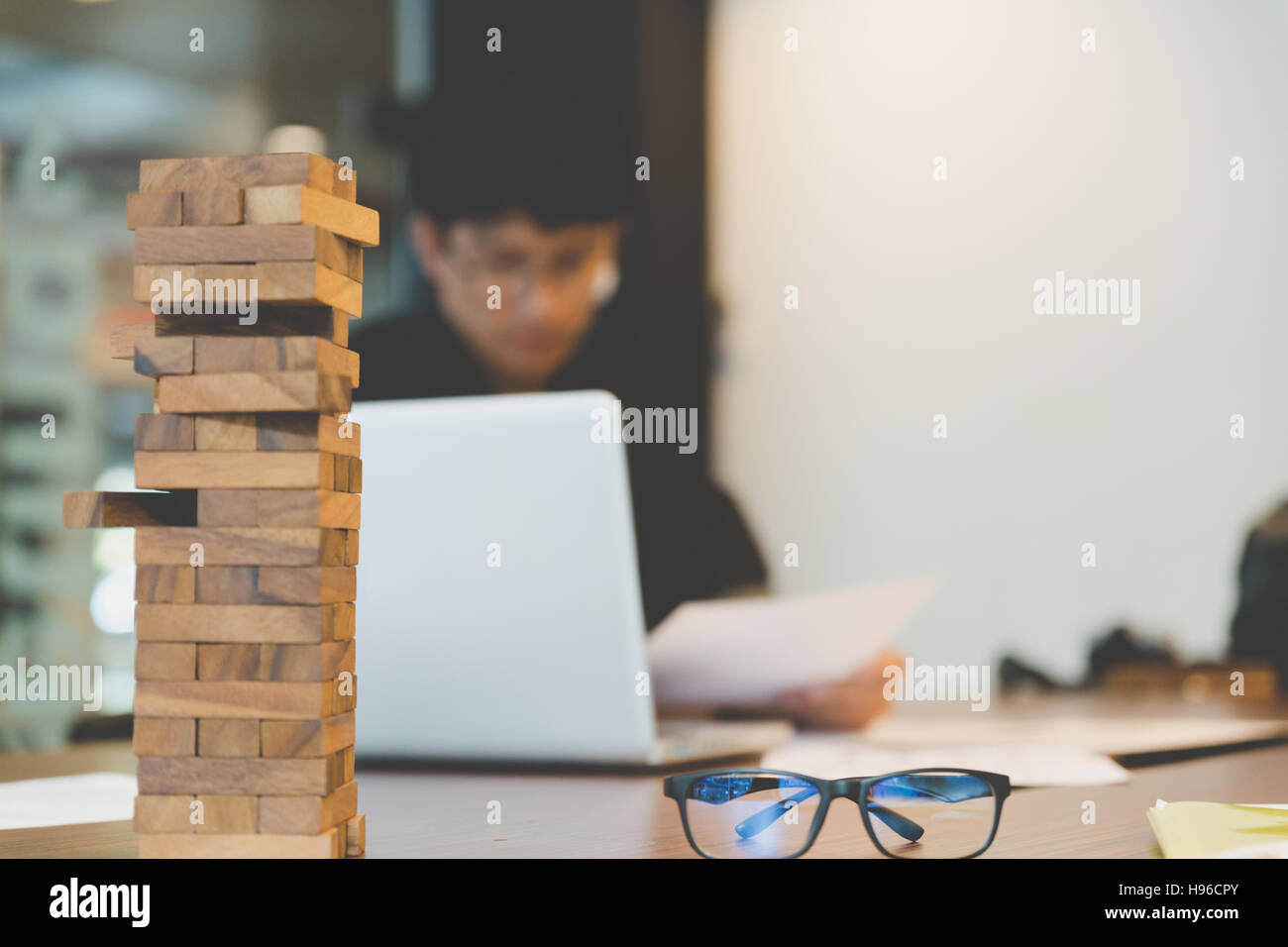 wood blocks stack game with background of businessman working in office ...