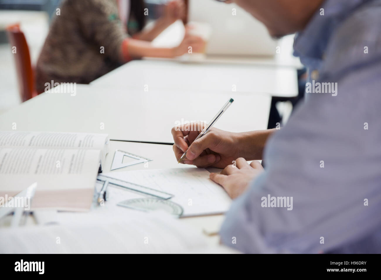 Male college student doing geometry math homework in library Stock ...