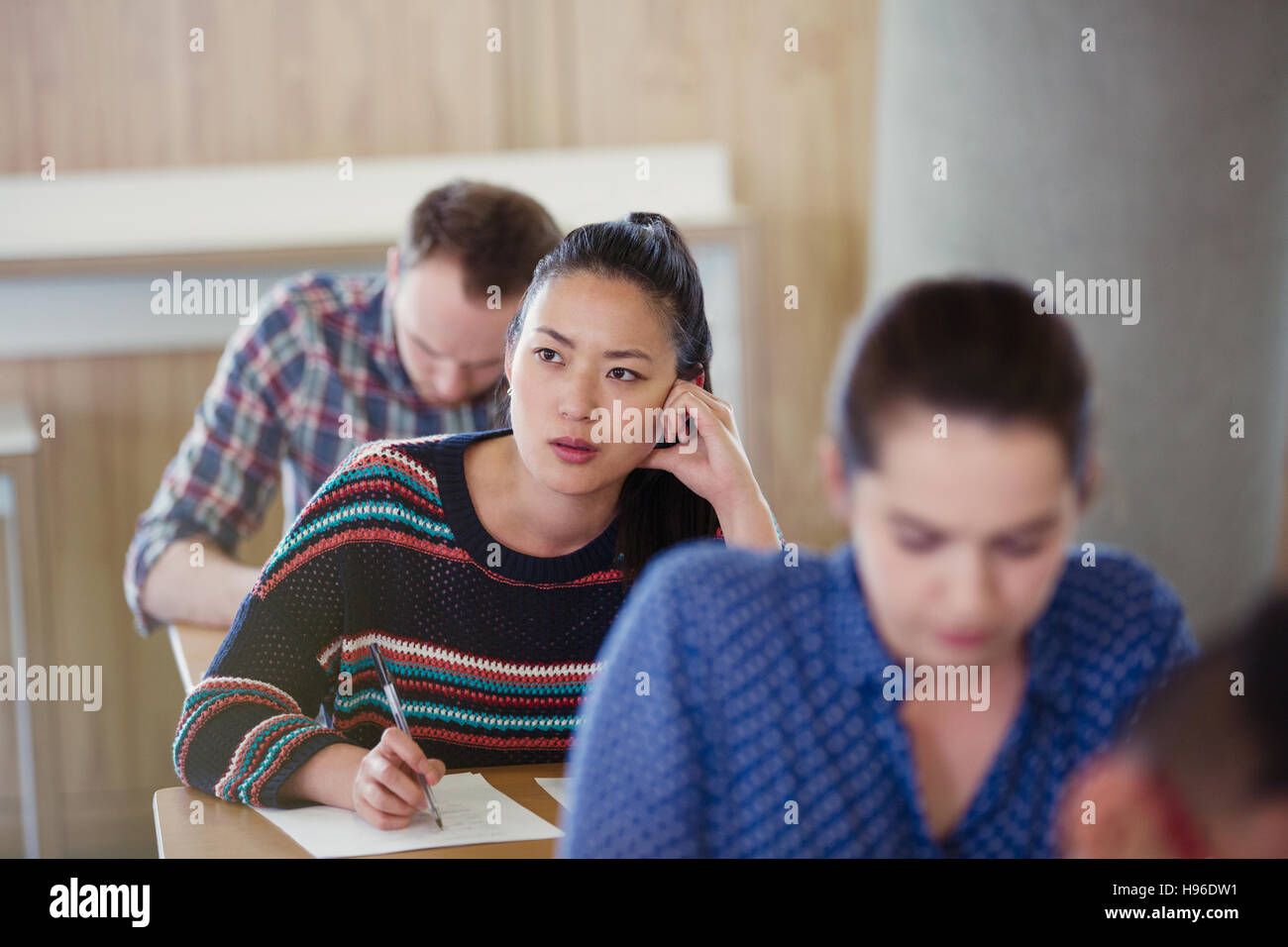 Pensive female college student taking test in classroom Stock Photo - Alamy